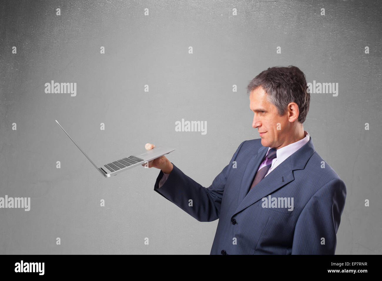 Handsome businessman holding modern laptop Stock Photo - Alamy