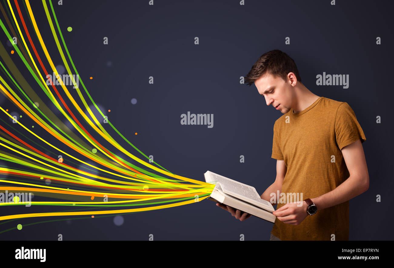 Handsome man reading a book while colorful lines are coming out of the ...