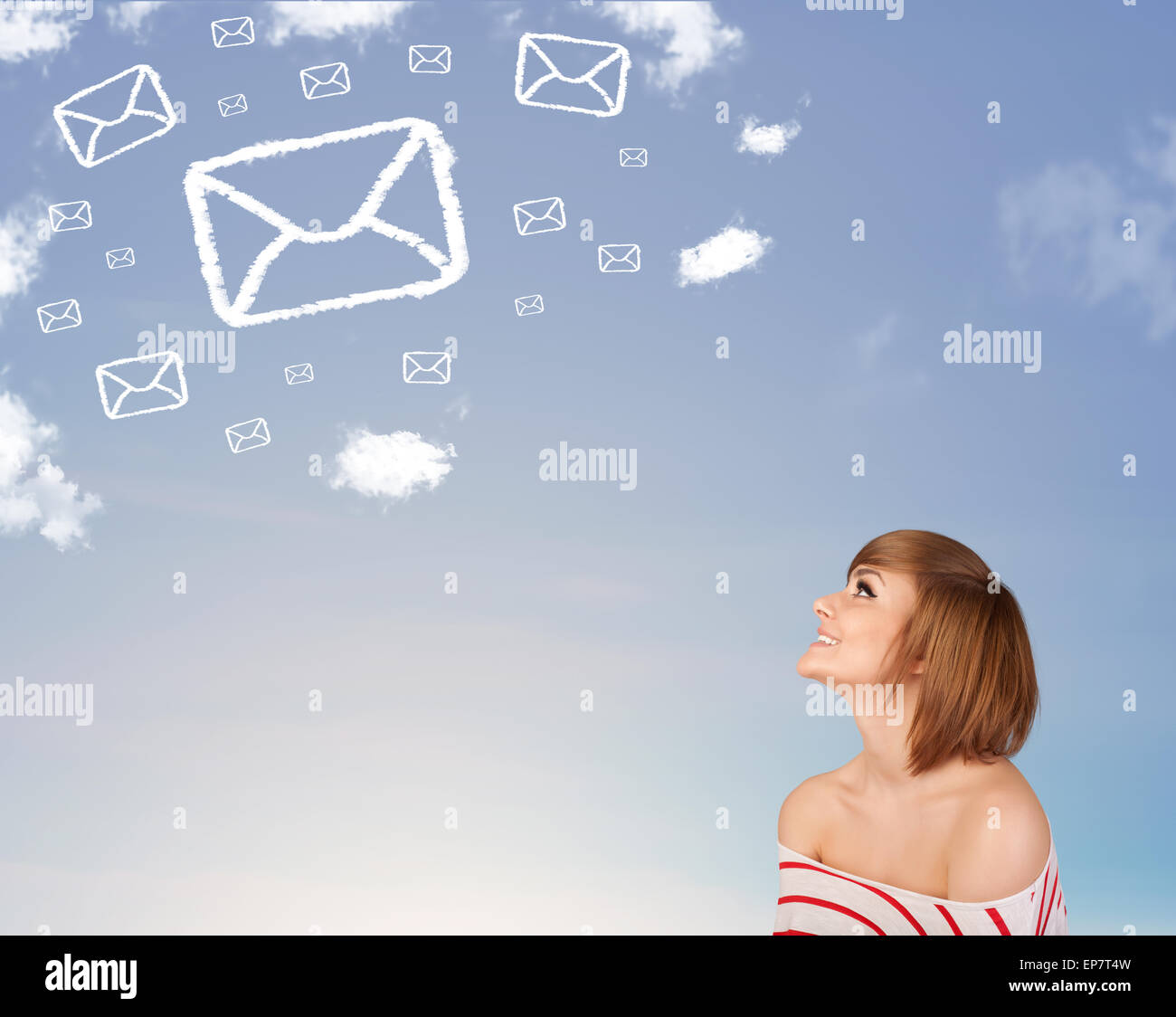 Young girl looking at mail symbol clouds on blue sky Stock Photo - Alamy