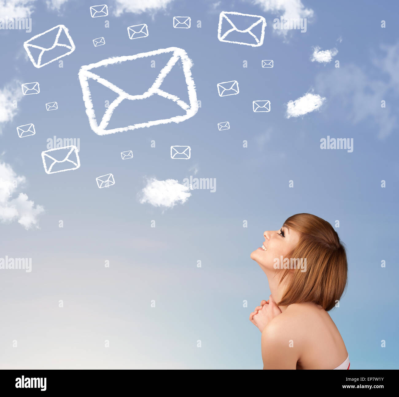 Young girl looking at mail symbol clouds on blue sky Stock Photo - Alamy