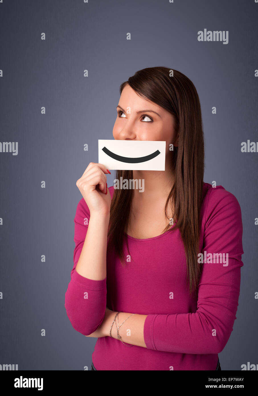 Happy pretty woman holding card with funny smiley Stock Photo - Alamy