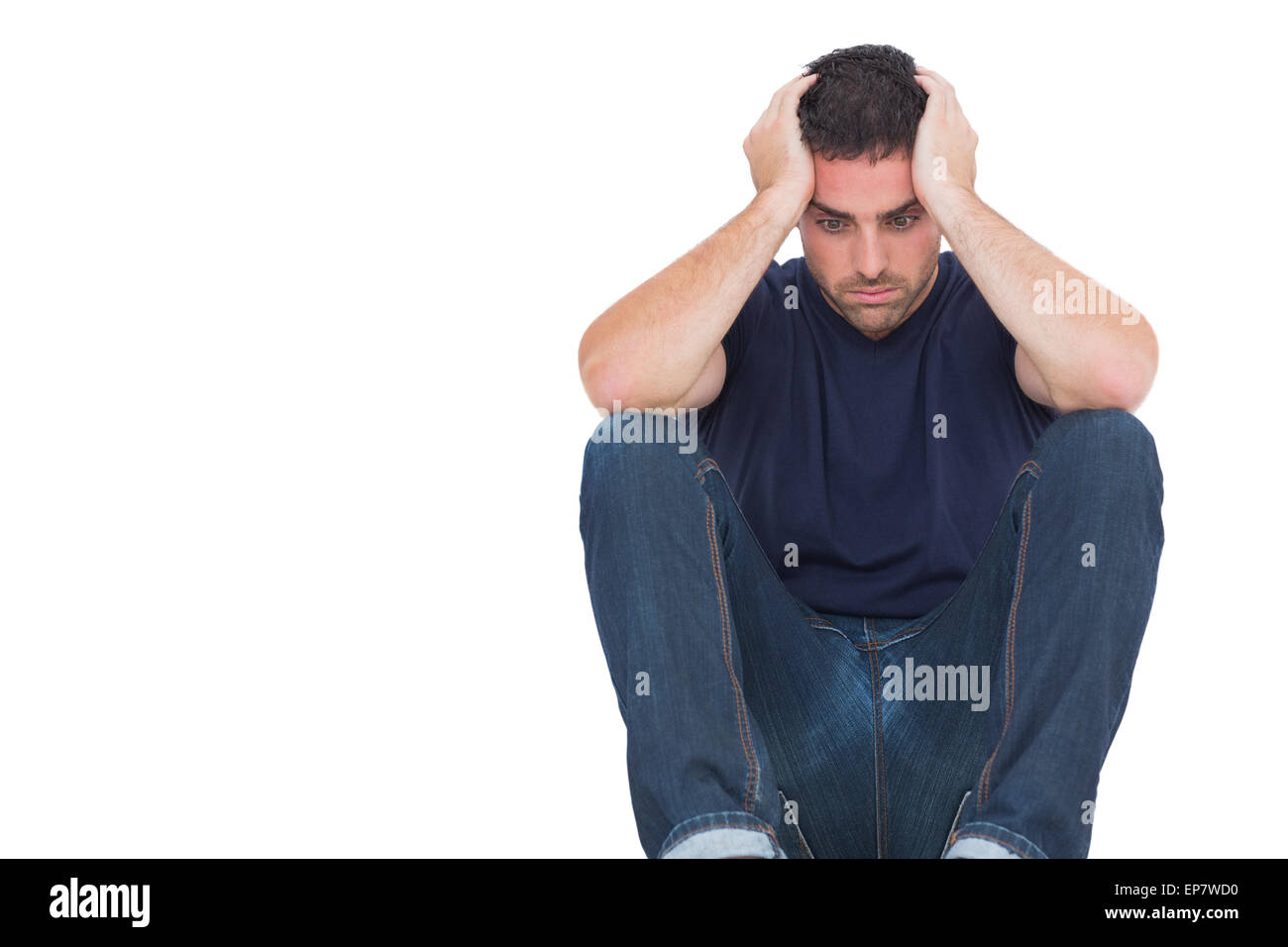Sad man sitting on the floor while holding his head Stock Photo - Alamy