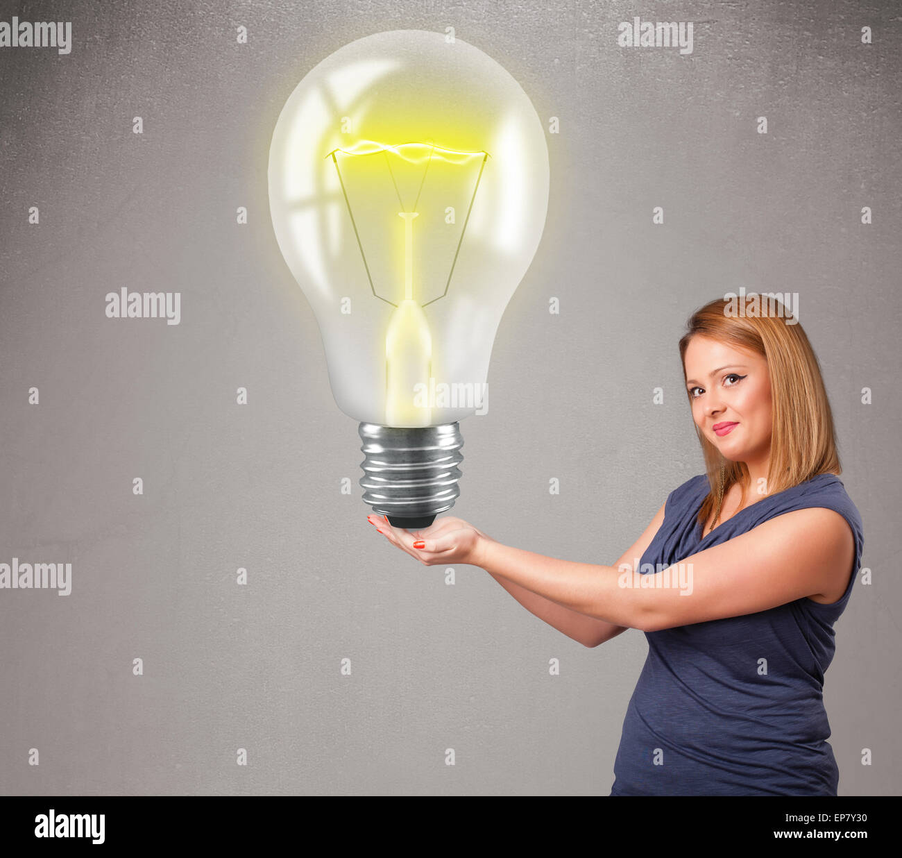 Beautiful lady holding realistic 3d light bulb Stock Photo - Alamy