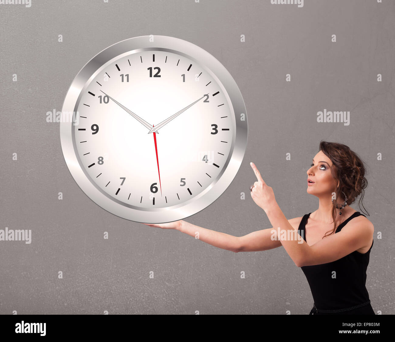 Attractive lady holding a huge clock Stock Photo - Alamy