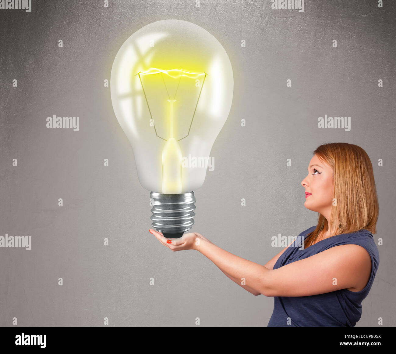 Beautiful lady holding realistic 3d light bulb Stock Photo - Alamy