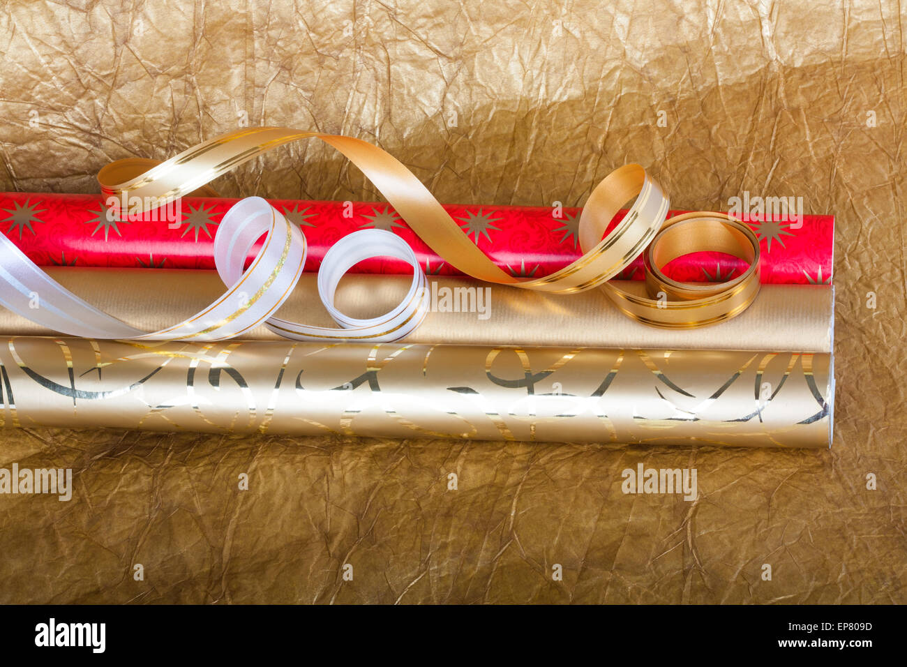 Rolls of multicolored wrapping paper with streamer for gifts on gold ...