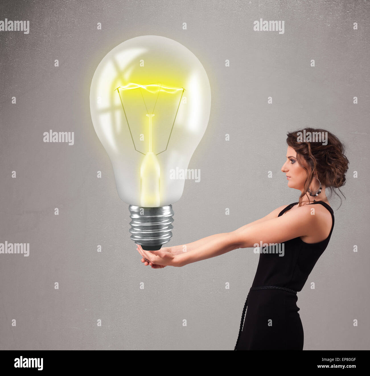 Beautiful lady holding realistic 3d light bulb Stock Photo - Alamy
