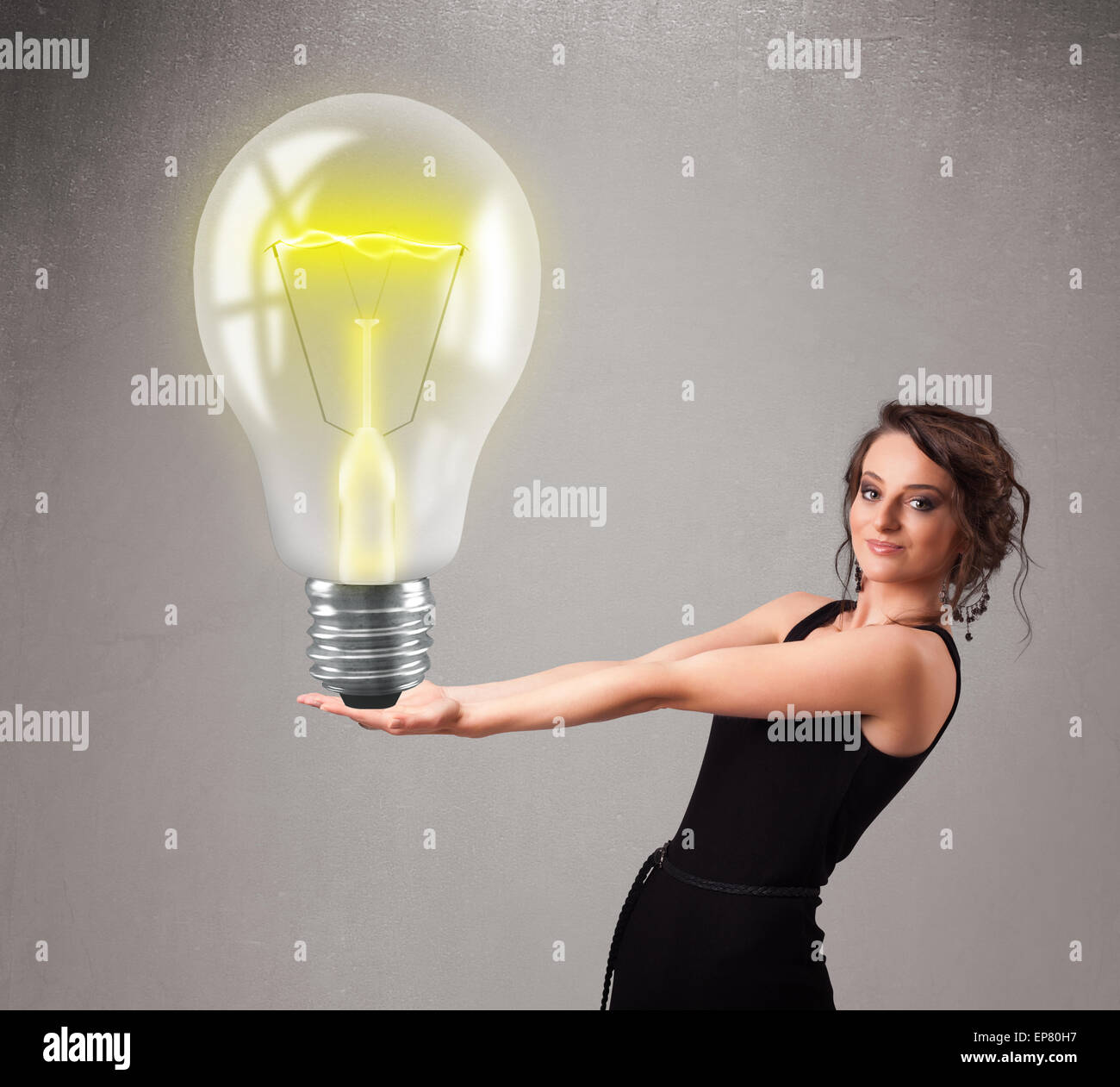 Beautiful lady holding realistic 3d light bulb Stock Photo - Alamy