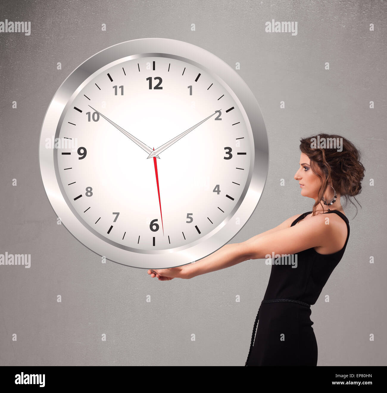 Attractive lady holding a huge clock Stock Photo - Alamy