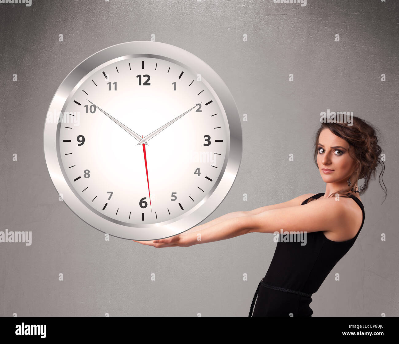 Attractive lady holding a huge clock Stock Photo - Alamy