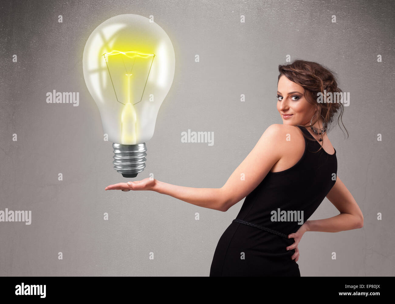 Beautiful lady holding realistic 3d light bulb Stock Photo - Alamy