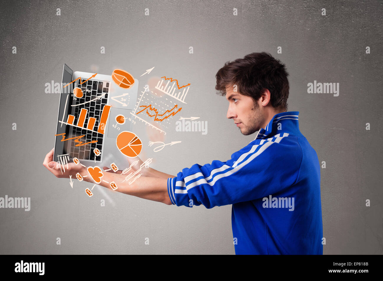Handsome man holding laptop with graphs and statistics Stock Photo - Alamy