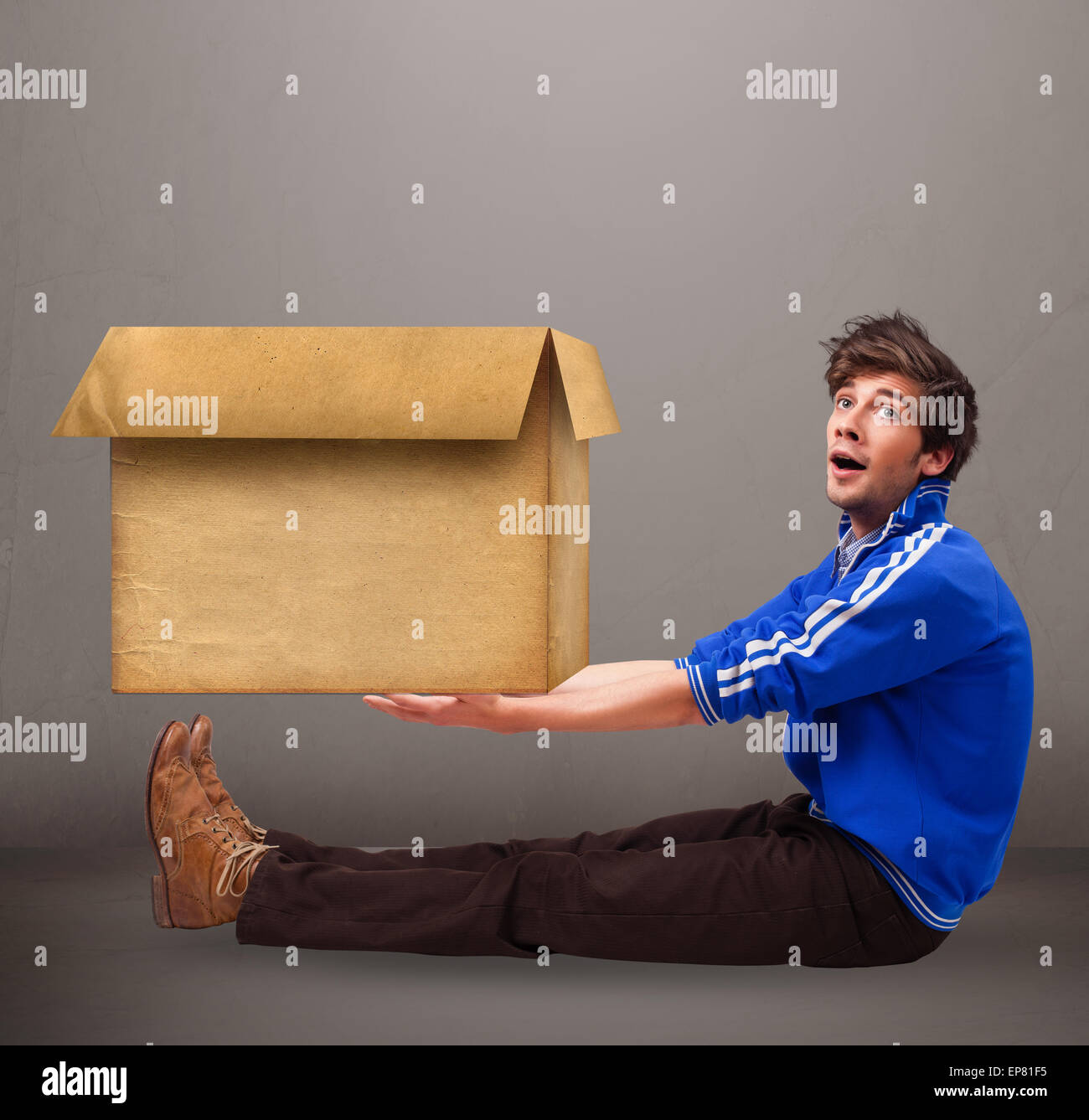 Goog-looking man holding an empty brown cardboard box Stock Photo - Alamy