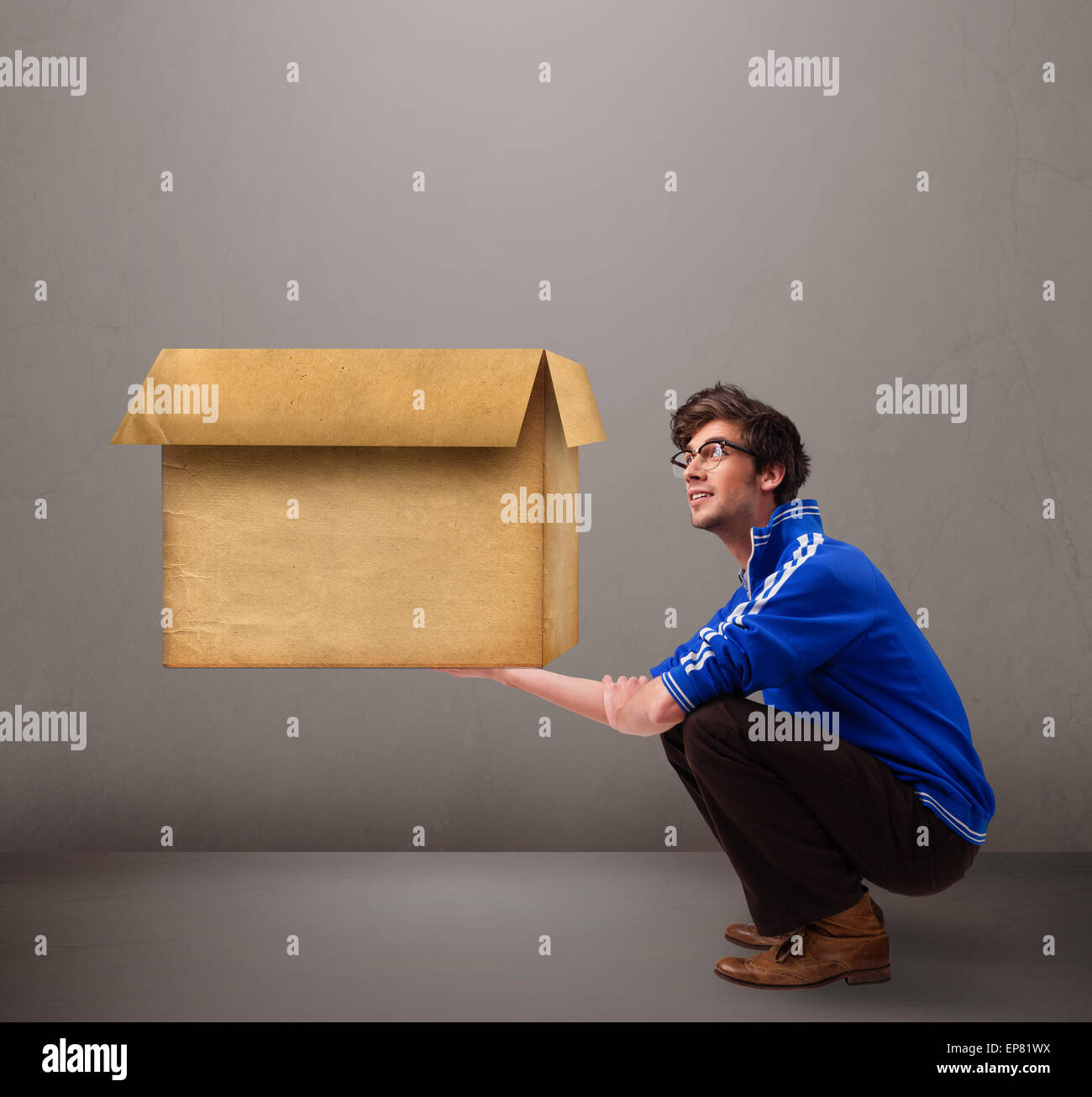 Goog-looking man holding an empty brown cardboard box Stock Photo - Alamy