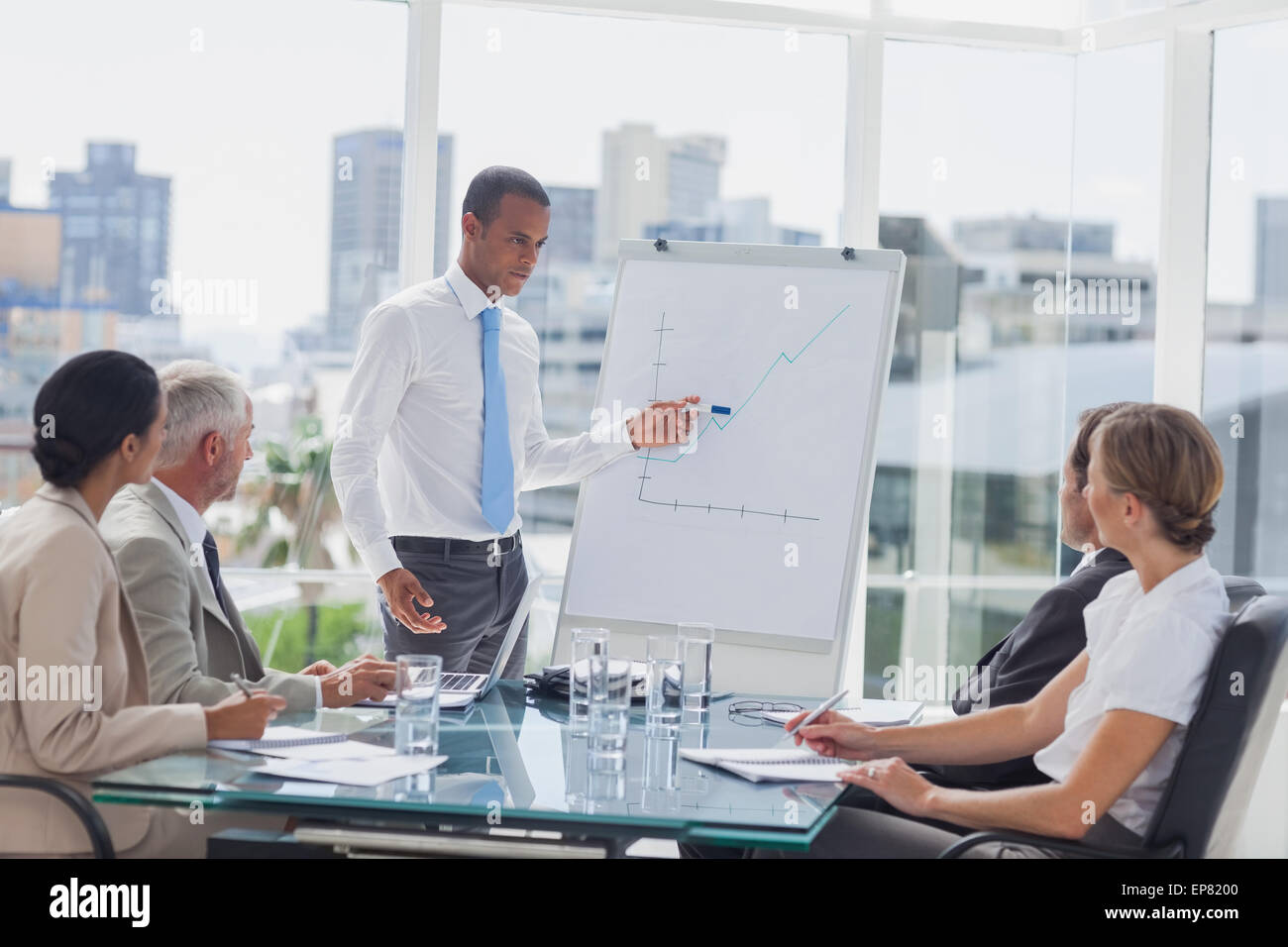 Manager pointing at a growing chart during a meeting Stock Photo - Alamy