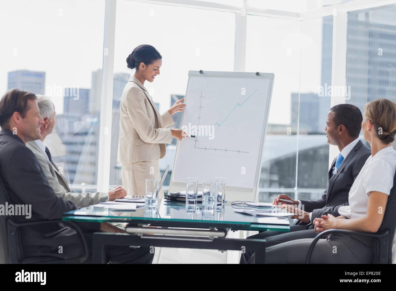 Businesswoman pointing at a growing chart during a meeting Stock Photo ...