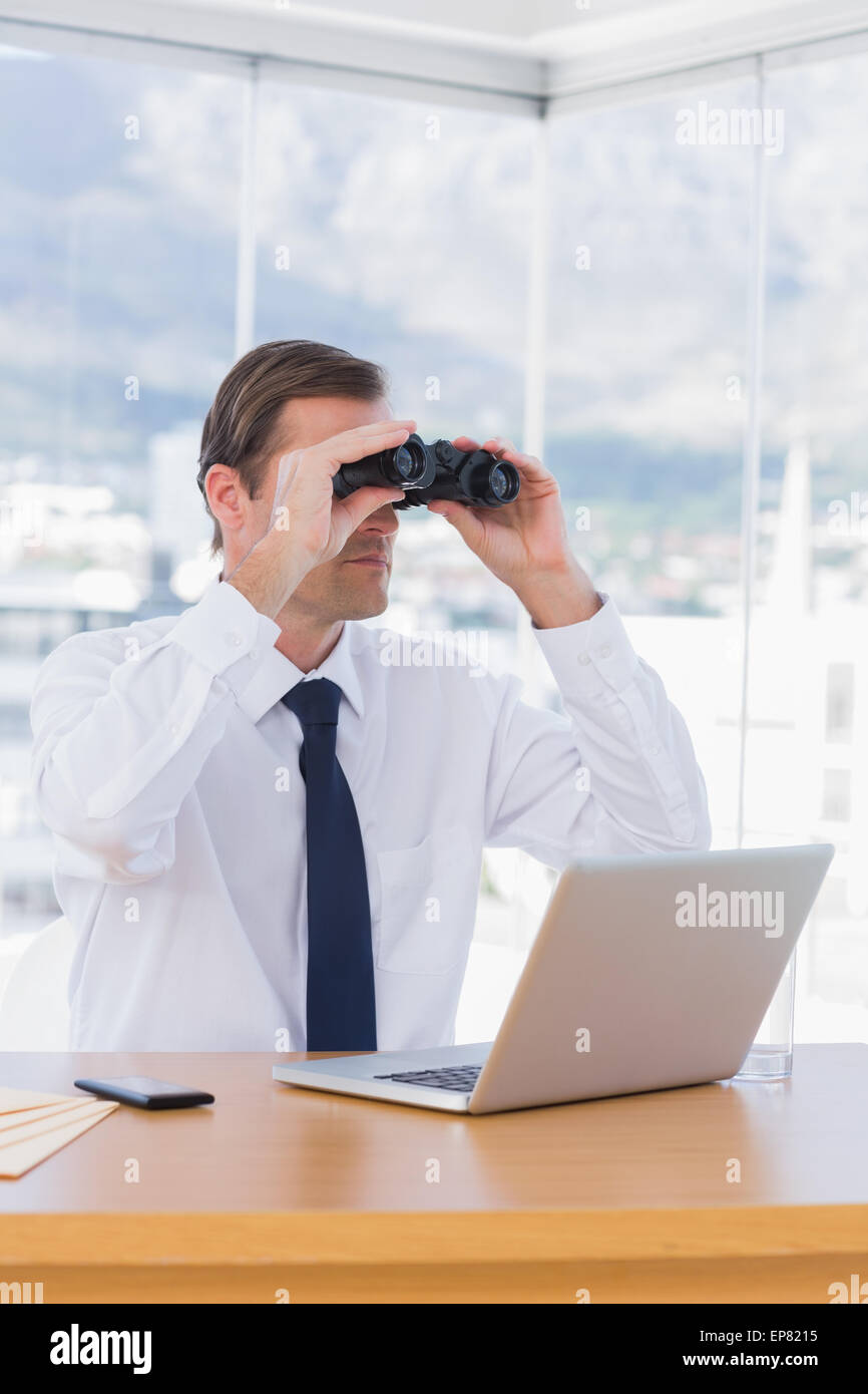 Businessman using binoculars while he is working Stock Photo - Alamy