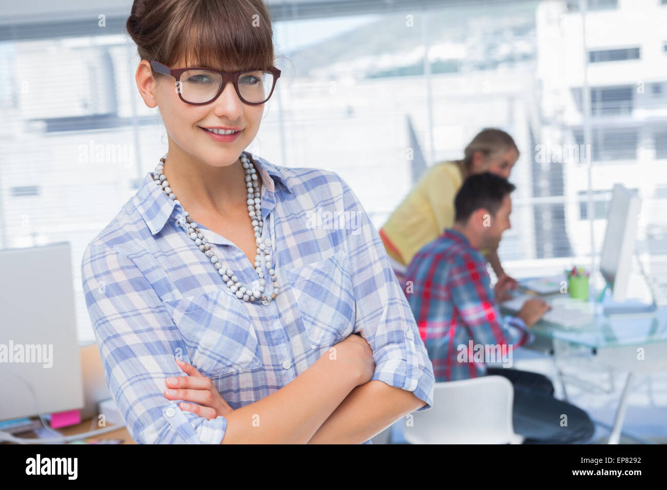 Portrait of a pretty designer with arms folded Stock Photo - Alamy