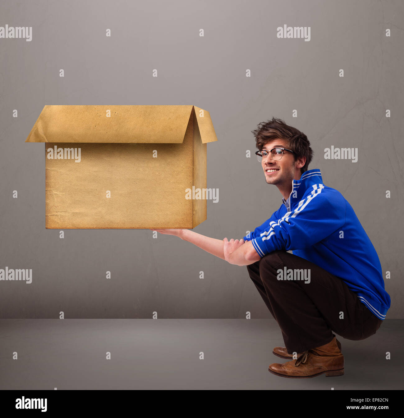Goog-looking man holding an empty brown cardboard box Stock Photo - Alamy