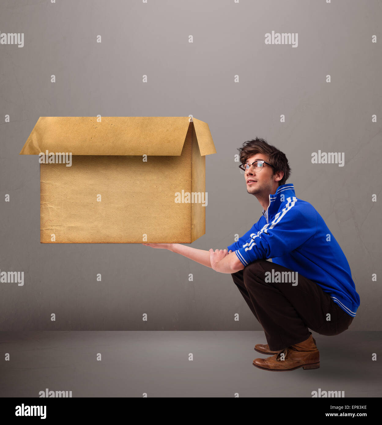 Goog-looking man holding an empty brown cardboard box Stock Photo - Alamy