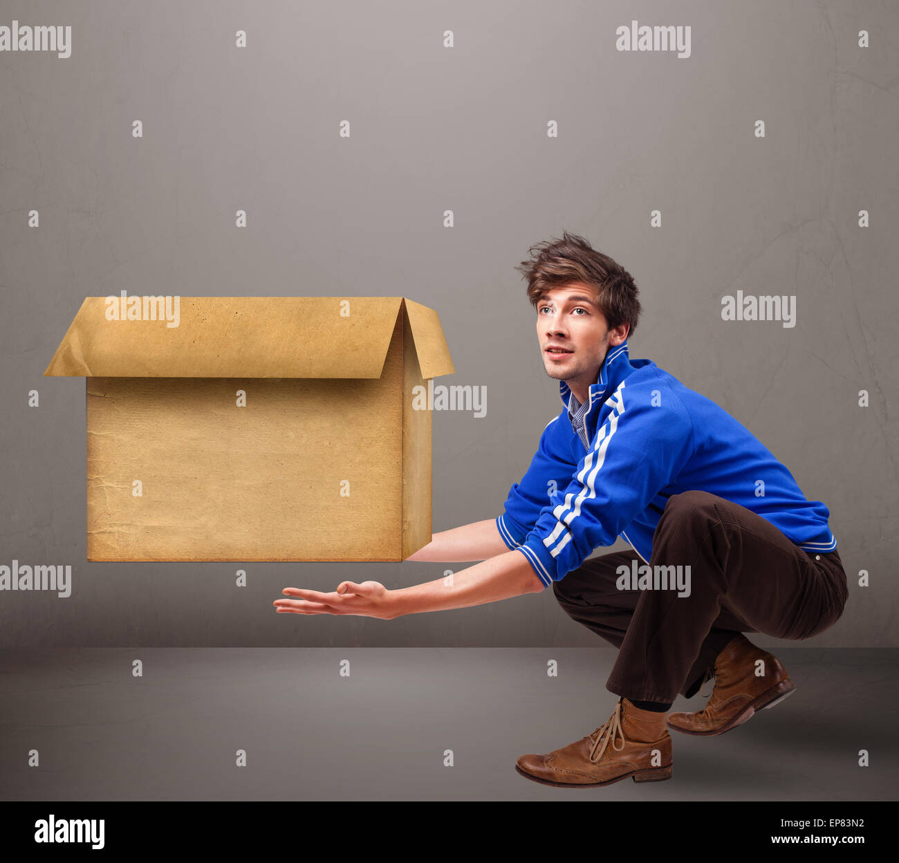 Goog-looking man holding an empty brown cardboard box Stock Photo - Alamy