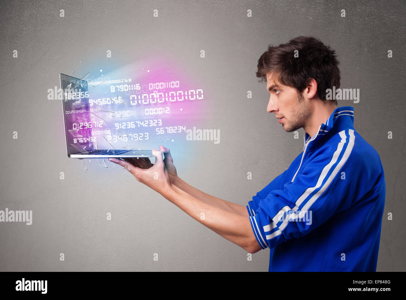 Casual man holding laptop with exploding data and numbers Stock Photo ...