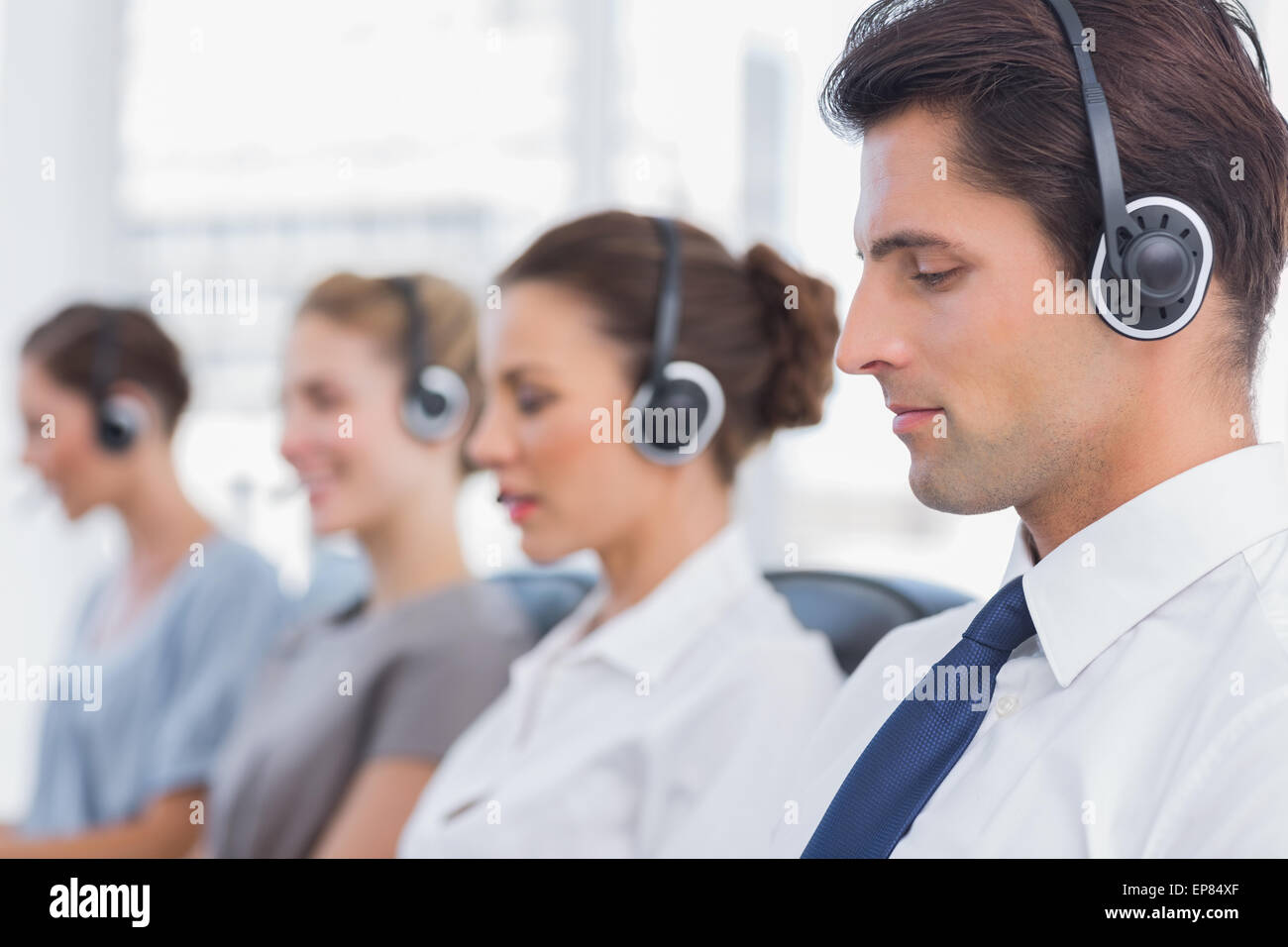 Group of agents sitting in line in a call centre Stock Photo - Alamy