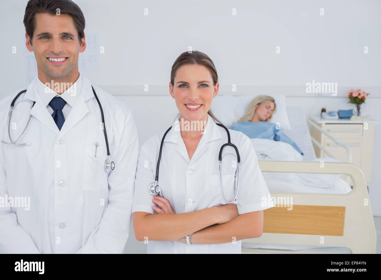 Two doctors standing in front of a hospitalized patient Stock Photo - Alamy