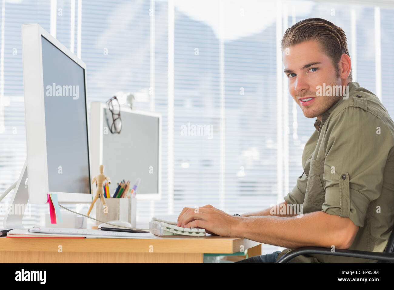 Smiling creative business employee working on computer Stock Photo - Alamy