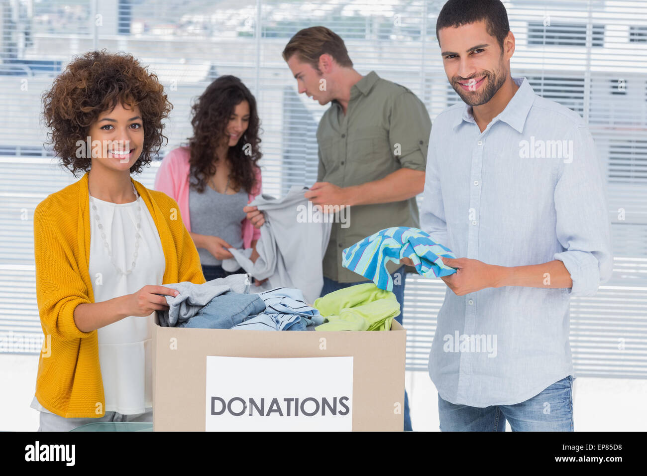 Team of volunteers taking out clothes from a donation box Stock Photo ...
