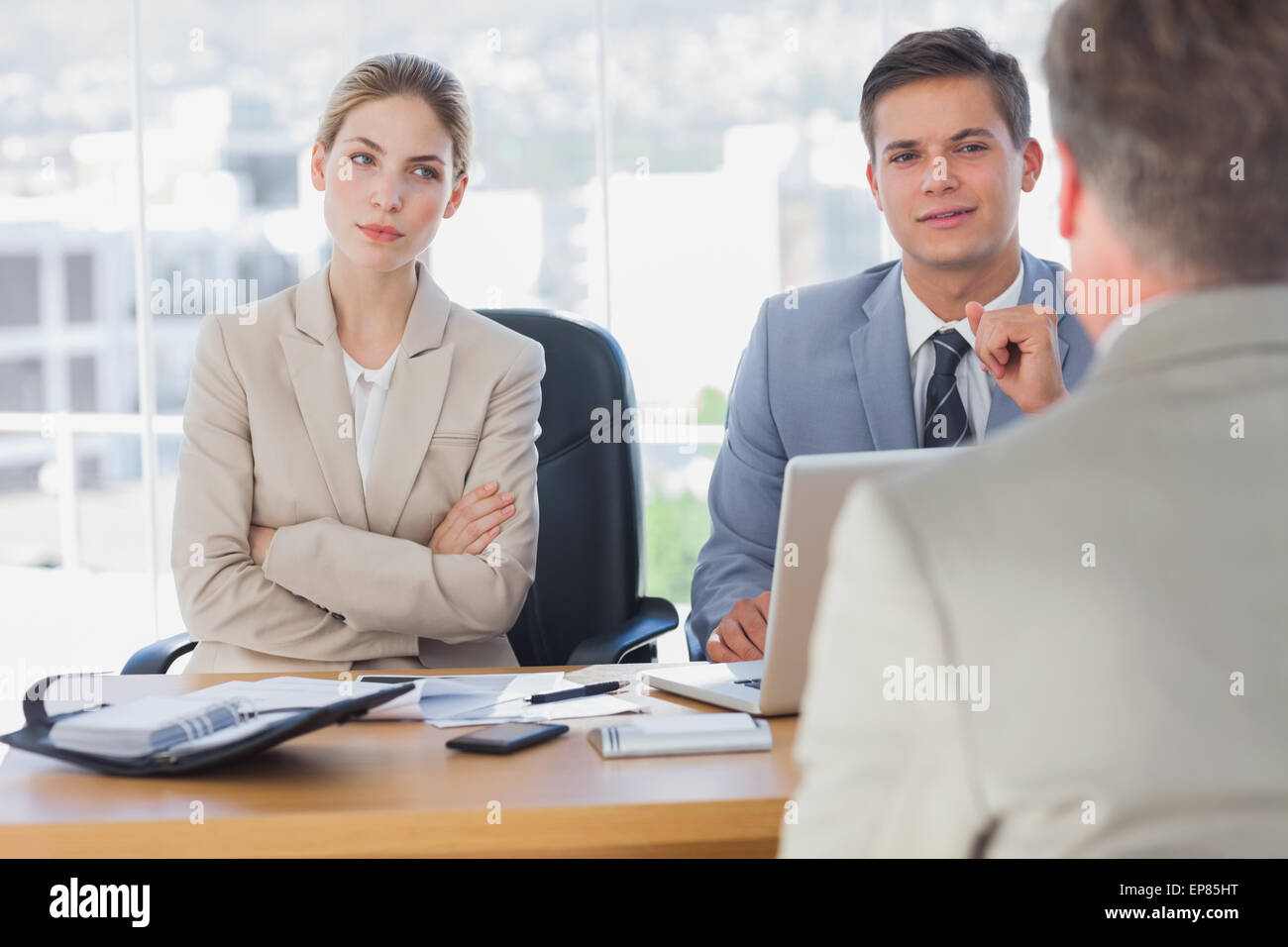 Happy business people interviewing business man Stock Photo - Alamy