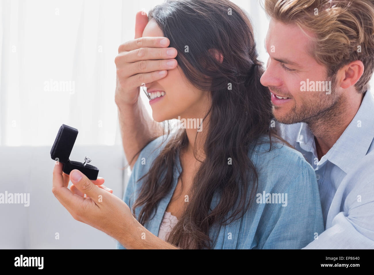 Man hiding his wifes eyes to offer her an engagement ring Stock Photo ...