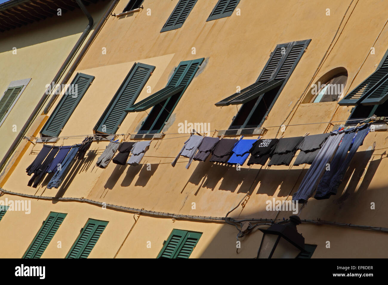 Washing hanging from the windows of a row of houses Stock Photo - Alamy