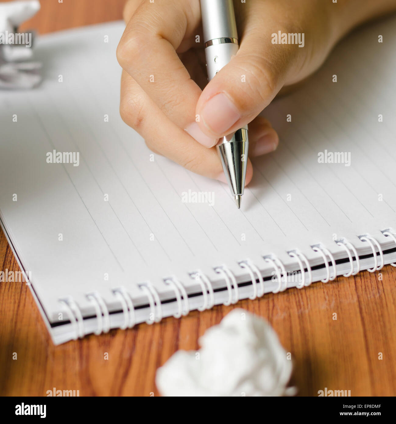 woman hand writing with pen on notebook.there are crumpled paper and ...
