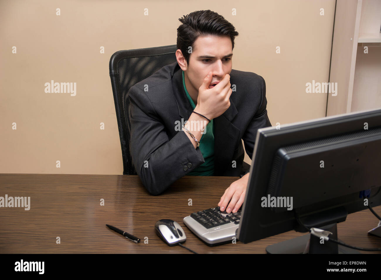 Preoccupied, worried, desperate young male worker staring at computer ...