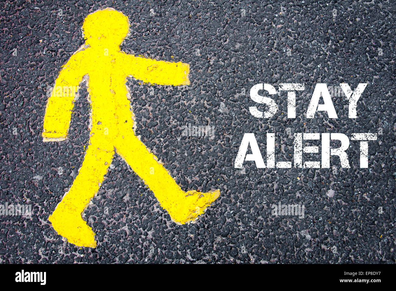 Yellow pedestrian figure on the road walking towards STAY ALERT ...