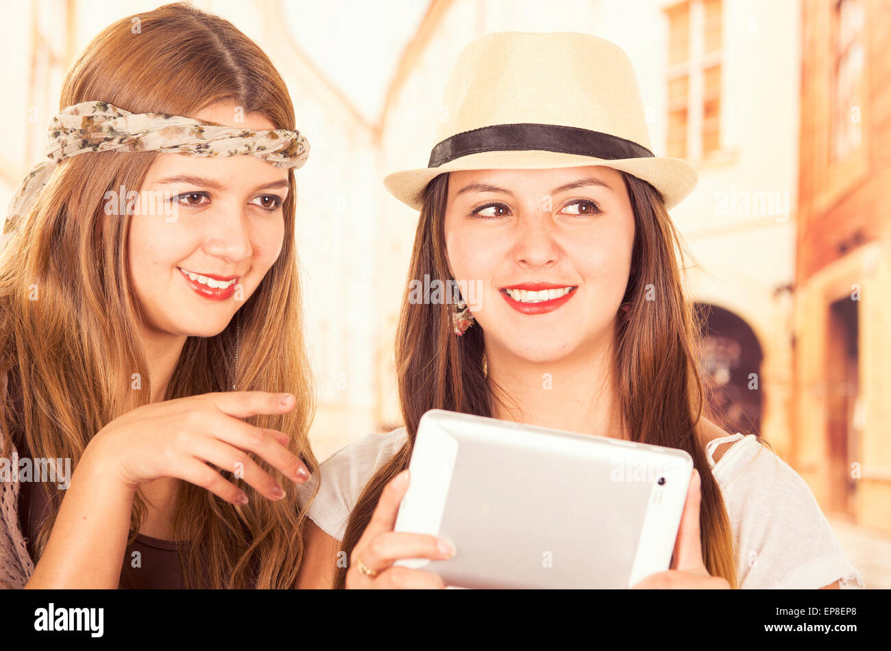 Beautiful young trendy girls using tablet Stock Photo - Alamy