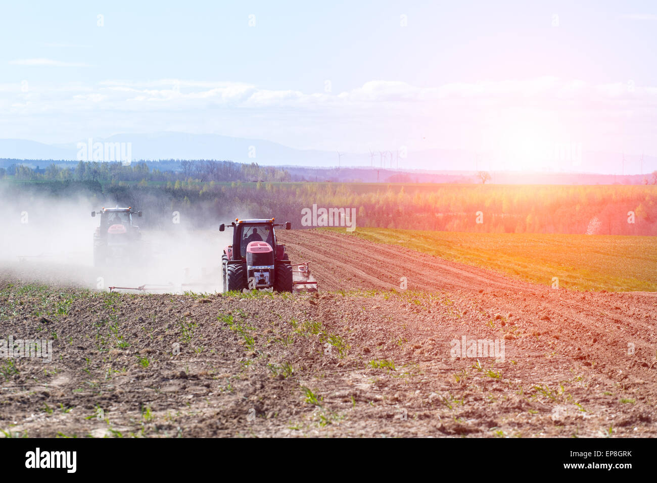 The tractor harrowing the large brown field in spring season Stock ...