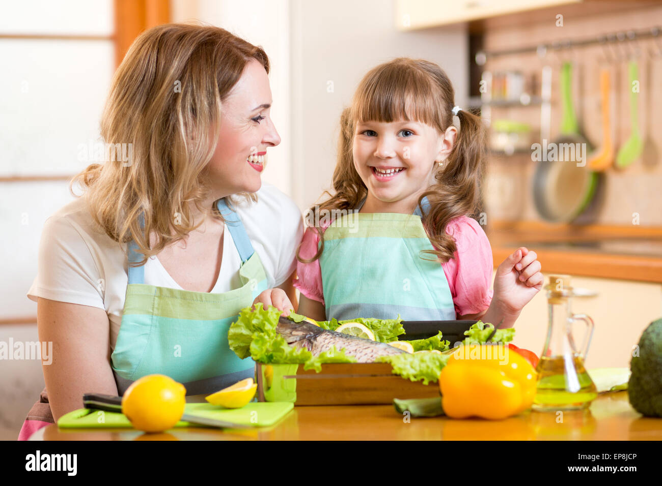 happy mom and kid cooking healthy food in kitchen Stock Photo - Alamy