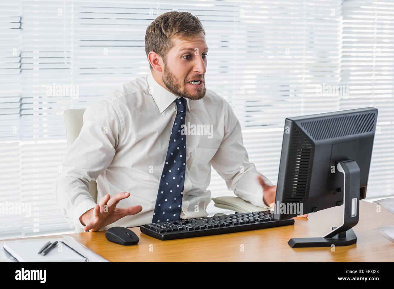 Frustrated businessman looking at his computer Stock Photo - Alamy