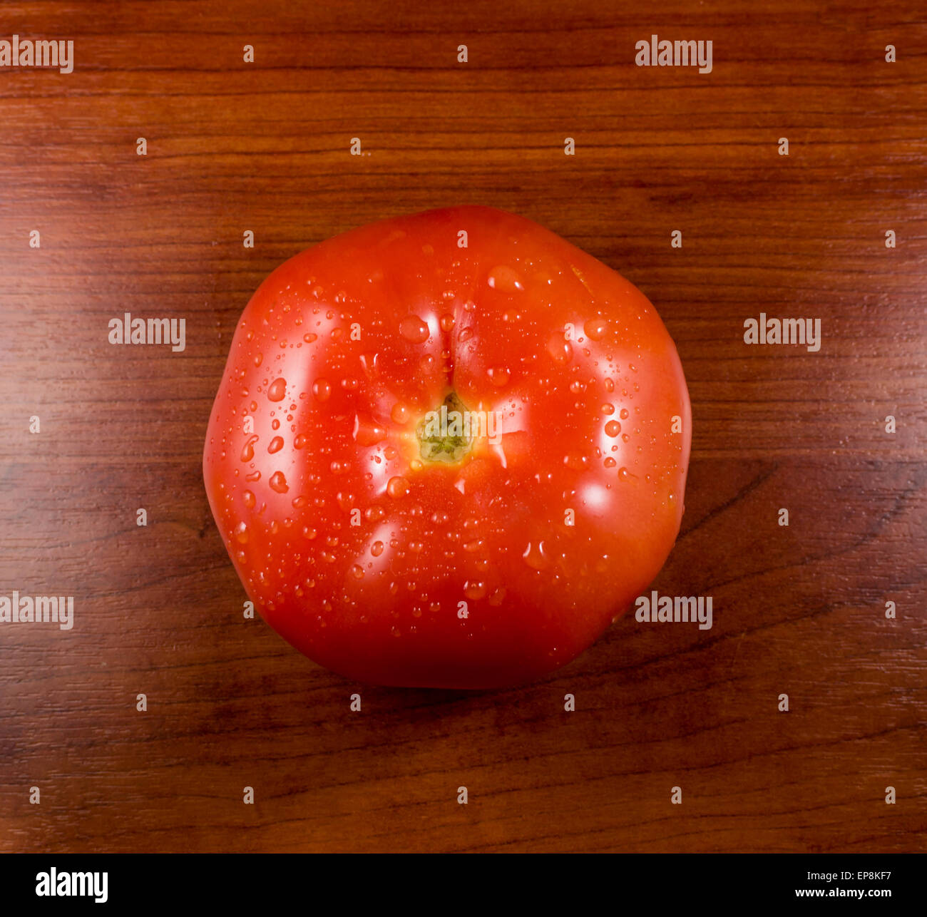 Juicy water sprayed tomato on rustic wood surface Stock Photo - Alamy