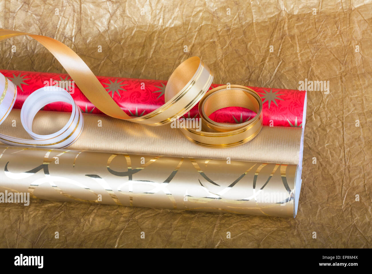 Rolls of multicolored wrapping paper with streamer for gifts on gold ...