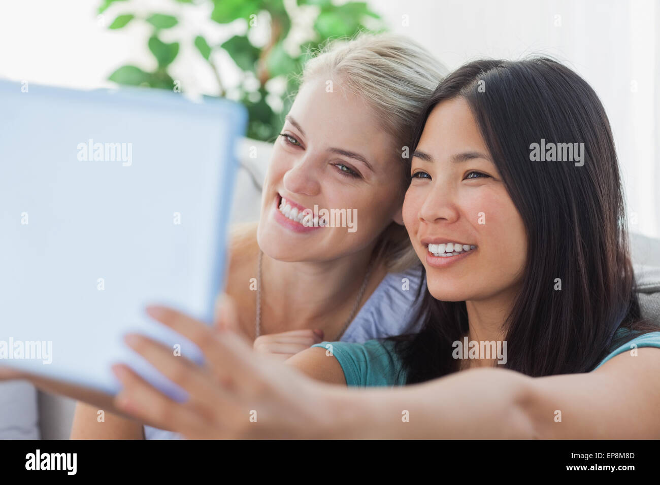 Two pretty friends taking photo with tablet pc Stock Photo - Alamy