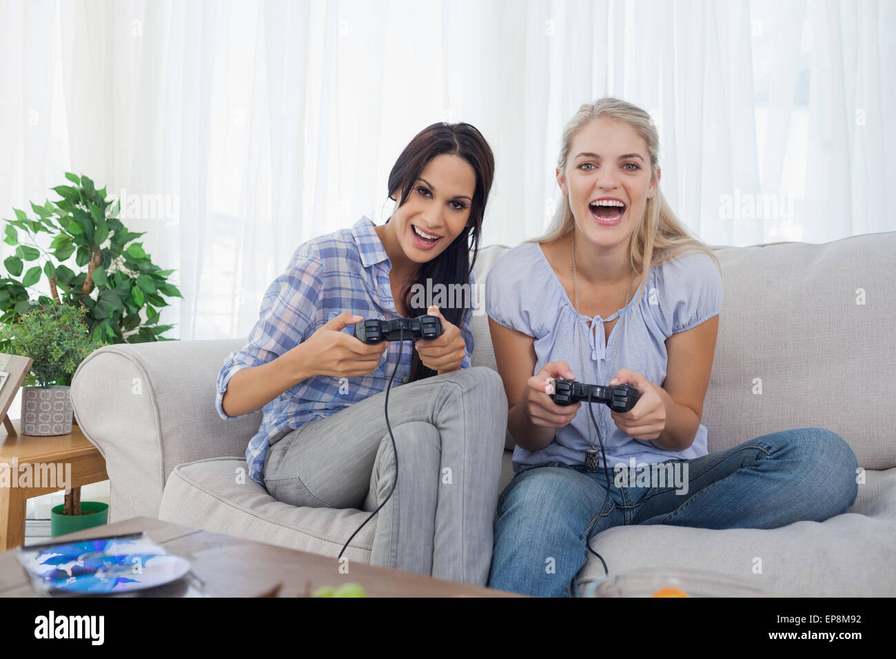 Happy friends playing video games and having fun Stock Photo - Alamy
