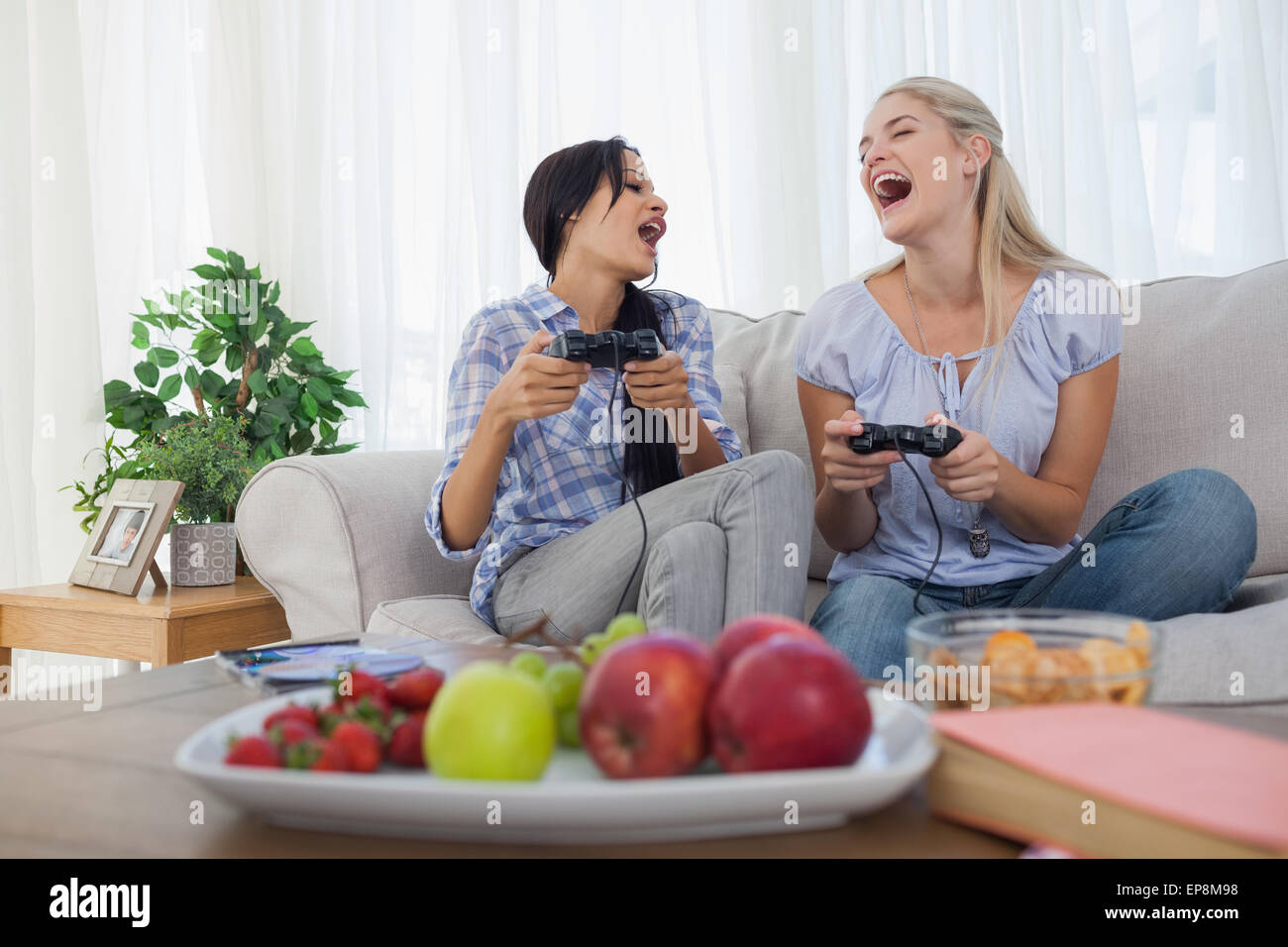 Laughing friends playing video games and having fun Stock Photo - Alamy