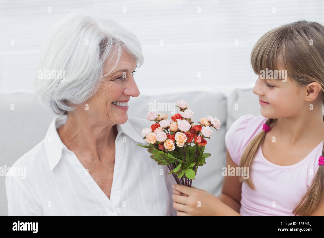 Cute girl giving a bunch of flowers to her grandmother Stock Photo - Alamy