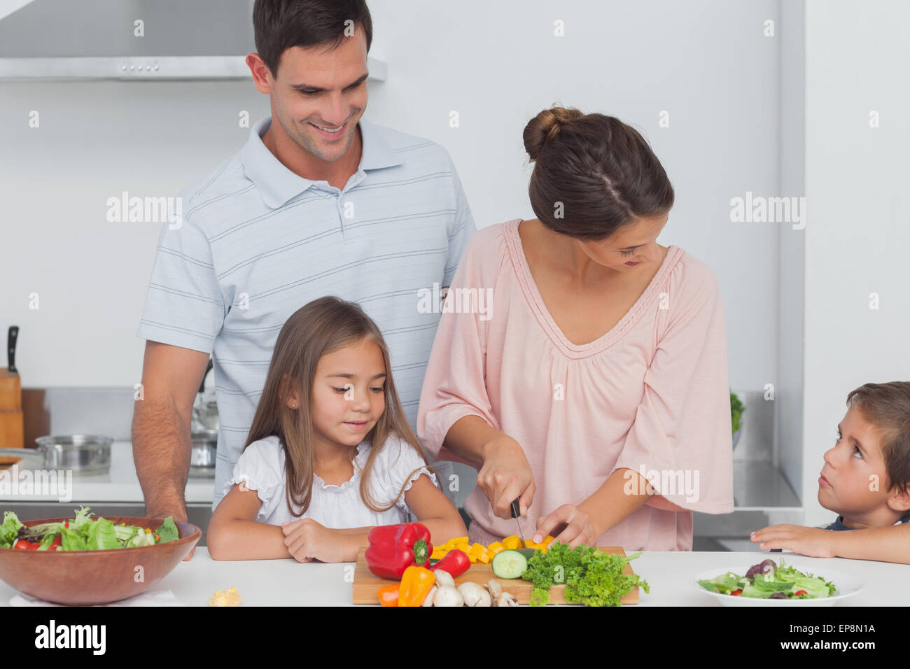 Children looking at their mother preparing vegetables Stock Photo - Alamy