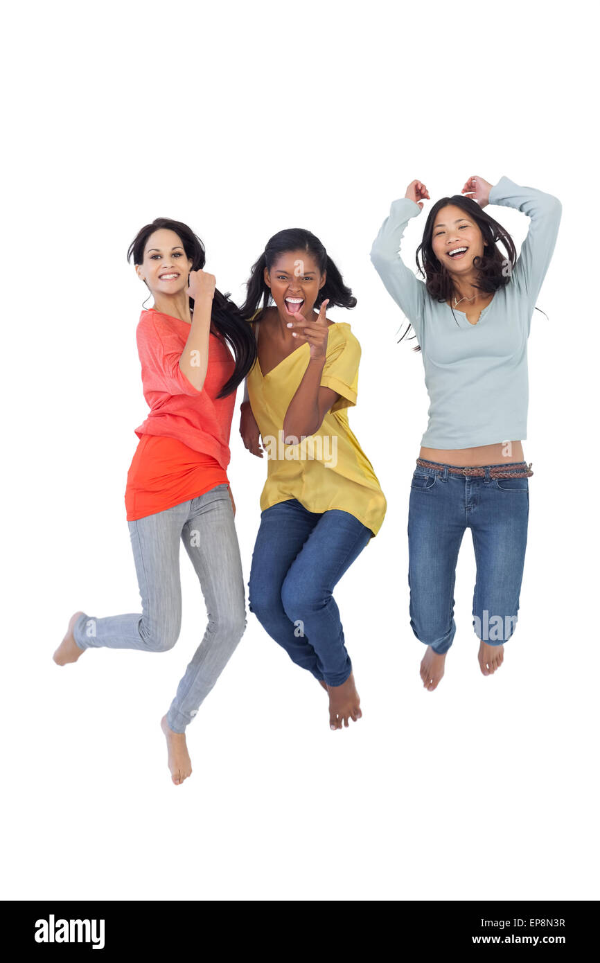 Diverse young women jumping and looking at camera Stock Photo - Alamy