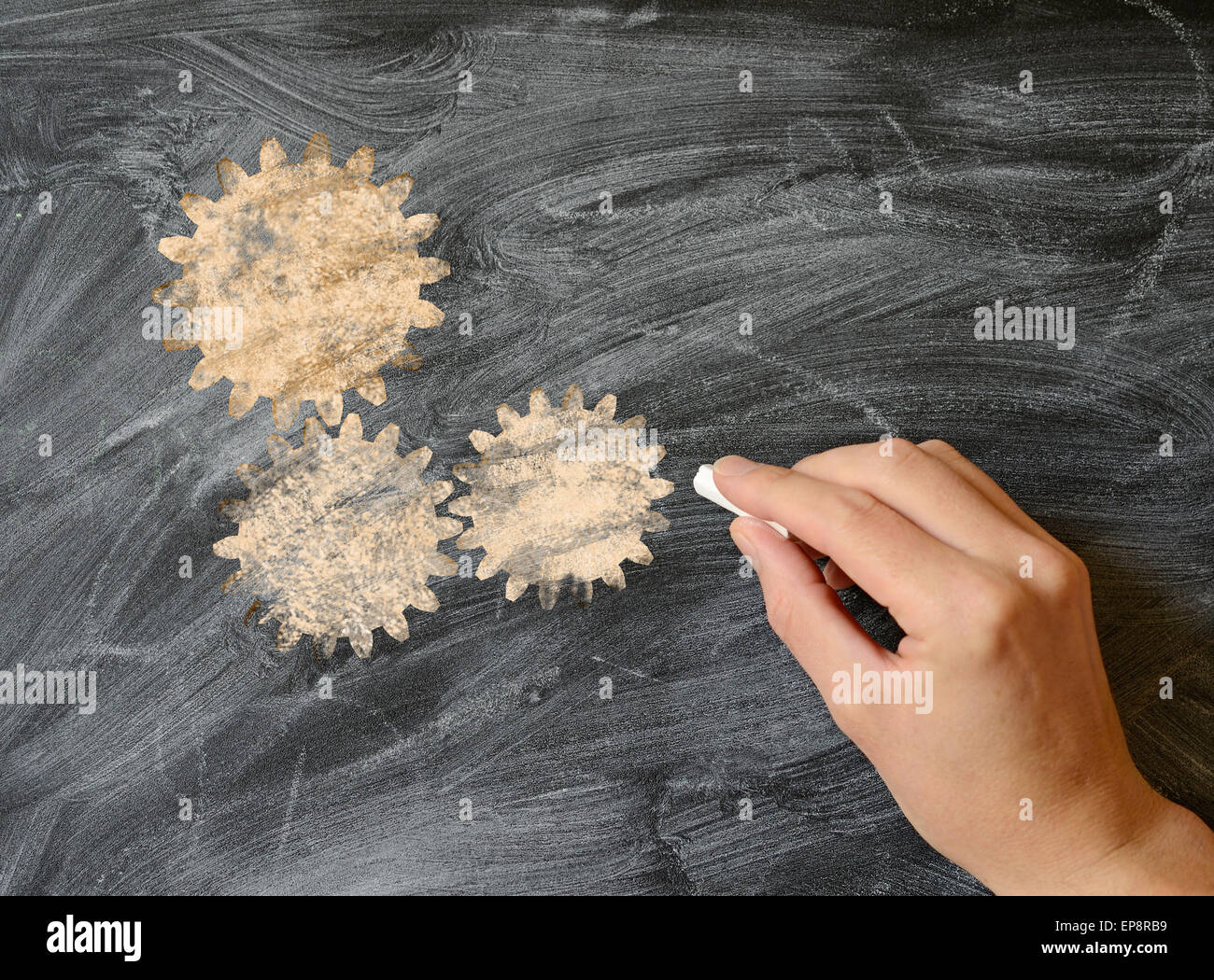Hand writing with chalk on a blackboard, Teamwork concept with cog ...