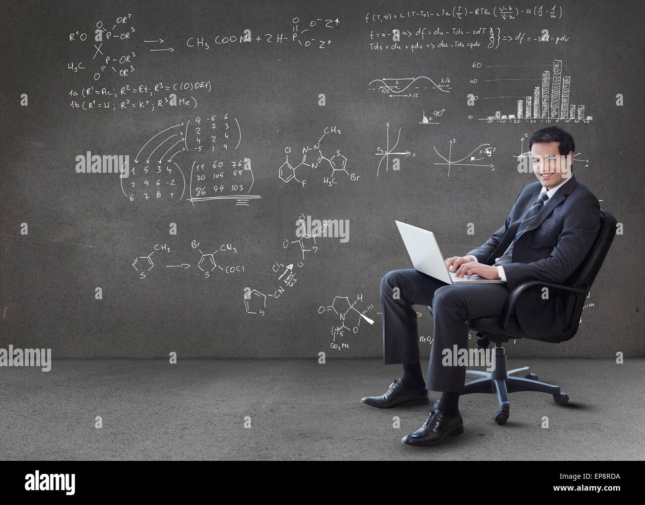 Businessman typing on his laptop with maths equations on wall Stock ...